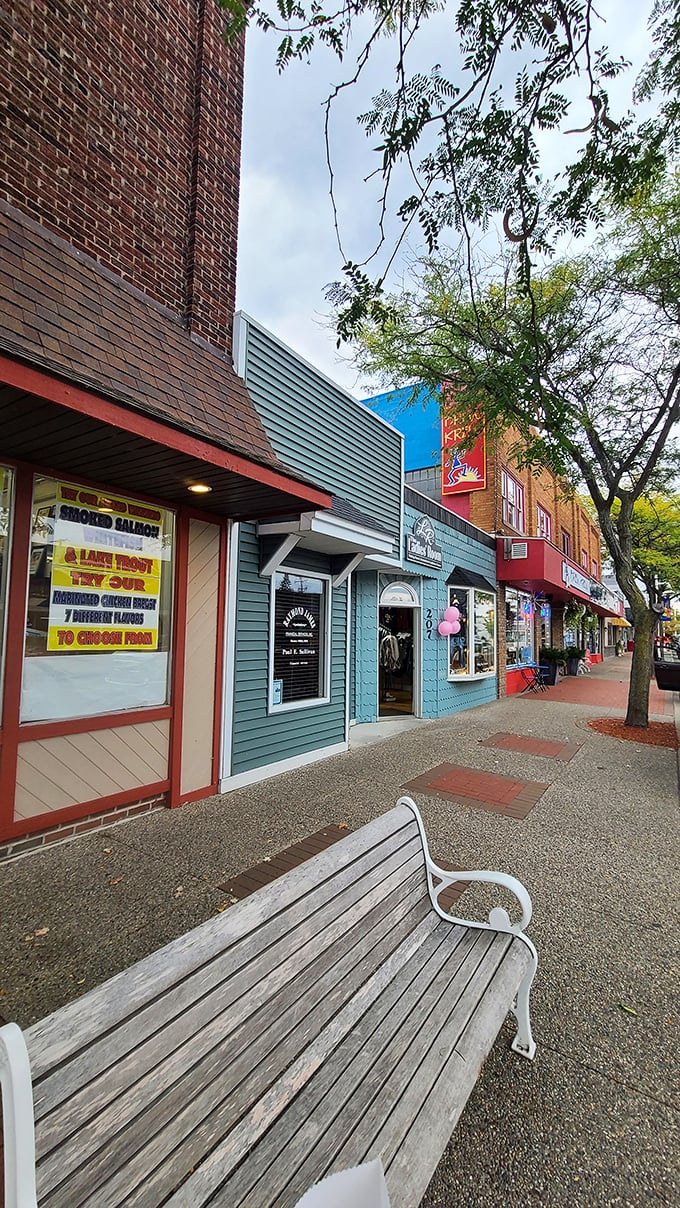 Colorful storefronts in varying shades create East Tawas' distinctive streetscape palette. That bench invites you to sit and watch the world pass by.