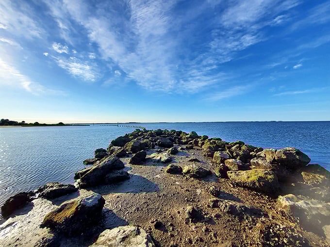 Rocky outcroppings punctuate the shoreline, creating natural tide pools where marine life thrives in miniature ocean worlds.
