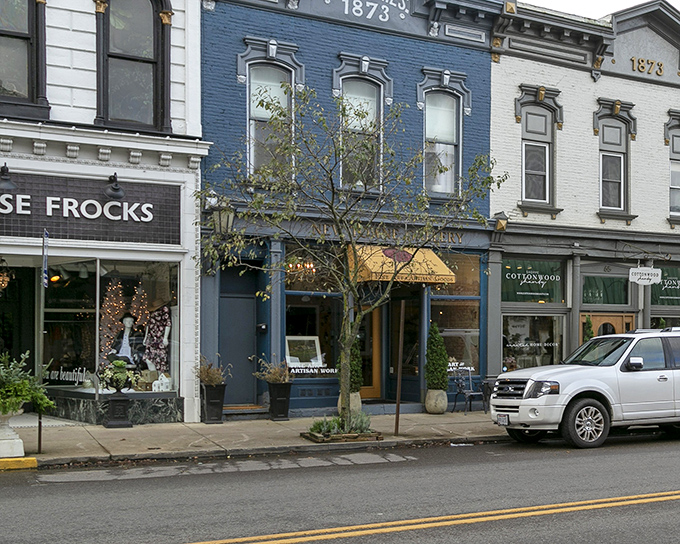 Blue facades and golden awnings create a streetscape that's both vibrant and dignified. These aren't just shops&mdash;they're keepers of community history.