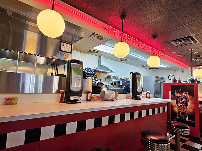 The counter seating puts you front row for the culinary show &ndash; red neon glow, checkered pattern, and stools that invite you to stay awhile.
