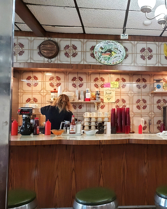 The counter where regulars become family. Those green stools have supported the weight of Fishtown's joys and sorrows for generations.