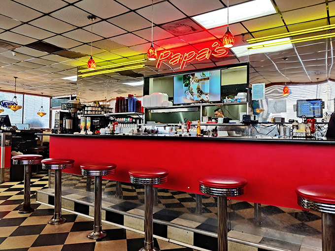 The counter where solo diners become regulars and servers remember your order before you've fully settled onto the classic red stool.