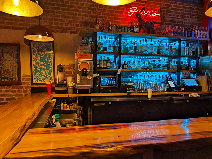 The bar glows like a tequila temple, where bottles stand at attention ready to transform ordinary moments into memorable New Orleans nights.