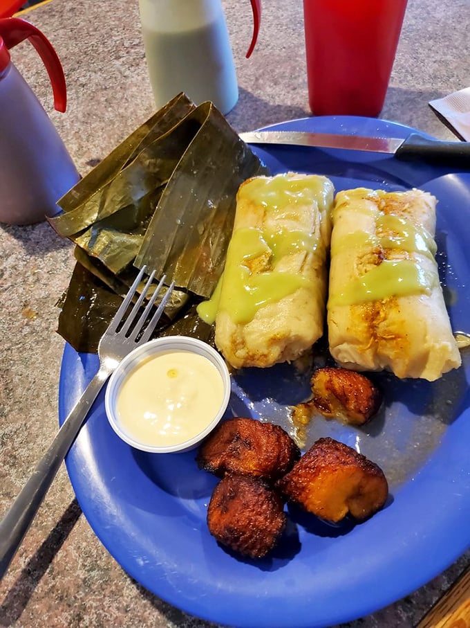 Tamales wrapped in banana leaves like precious gifts, flanked by fried plantains that deliver the perfect sweet counterpoint to savory perfection.