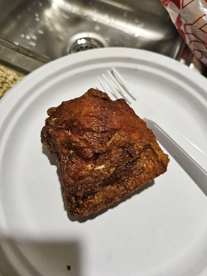 A single piece of chicken perfection on a humble paper plate&mdash;proof that sometimes the simplest things require the most expertise.