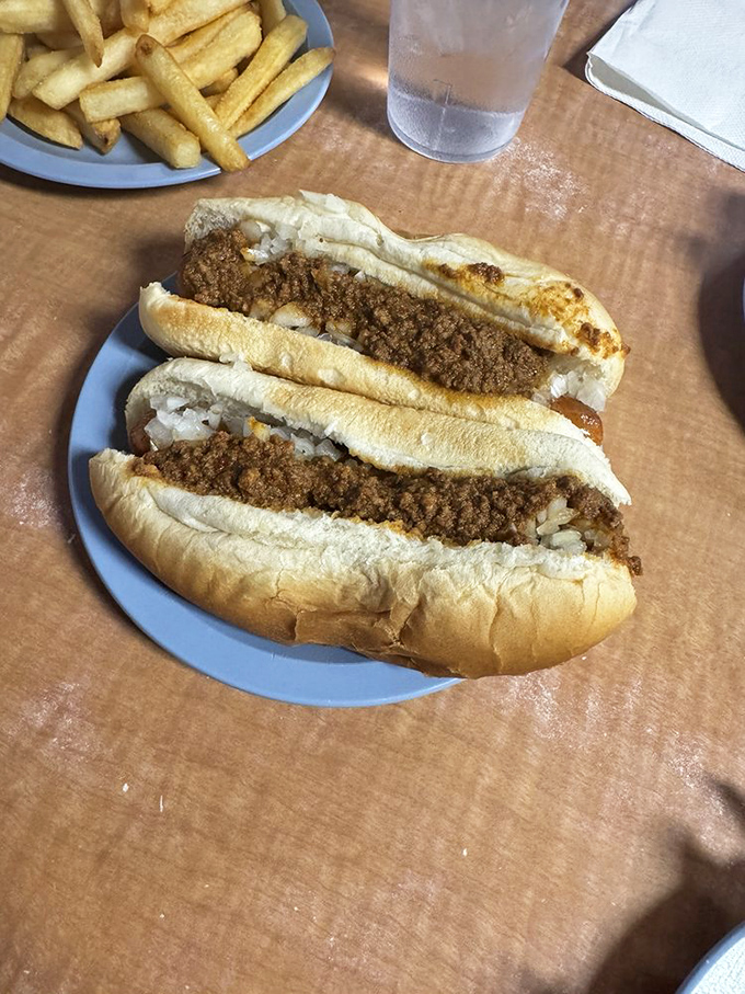Two chili dogs nestled side by side like old friends catching up. The onions add crunch while the soft buns cradle everything in carb-loaded comfort.