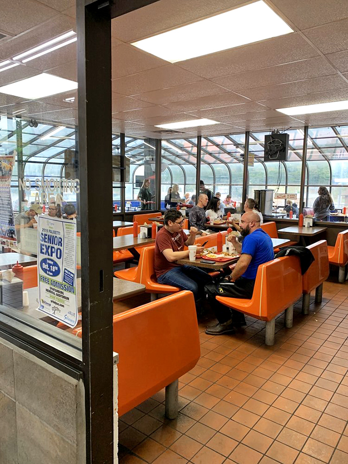 Where strangers become neighbors over shared appreciation of oversized portions. These orange booths have witnessed first dates, business deals, and family traditions.