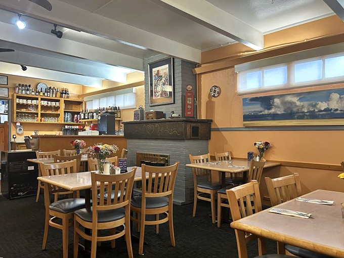 Warm wood tones, simple tables, and a fireplace create the kind of dining room where family stories are shared and new memories are made.