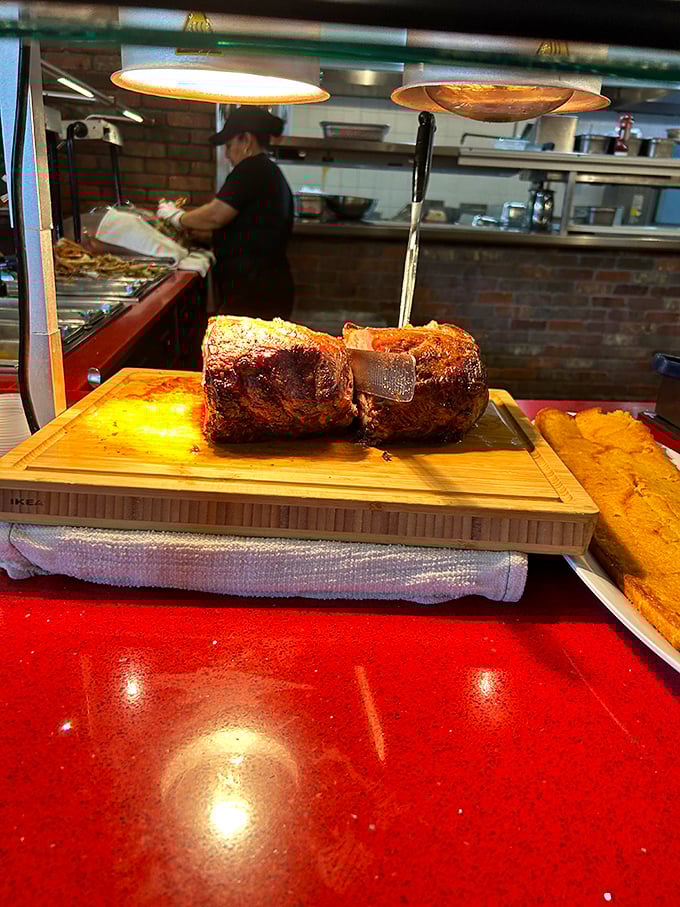 The prime rib carving station, where meat maestros slice portions of slow-roasted beef while cornbread waits patiently in the wings.