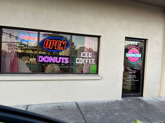 The neon glow beckons like a lighthouse for the sugar-deprived. Some follow stars; the wise follow illuminated donut signs.