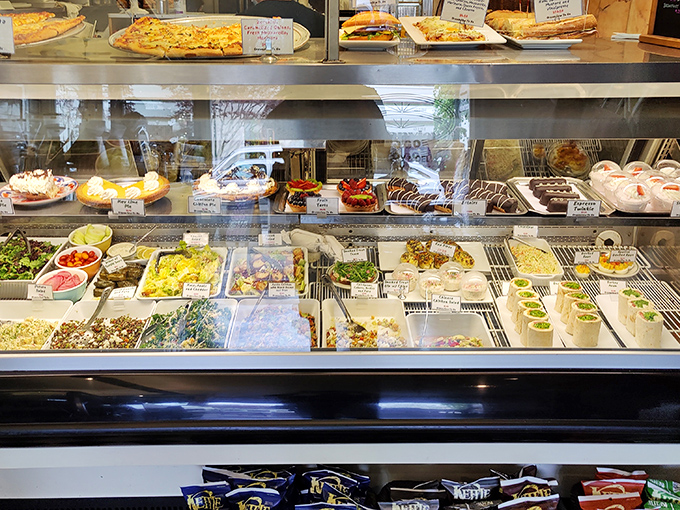 The display case&mdash;a museum of comfort where salads sit alongside chocolate-dipped delights, proving that balance in life is entirely optional.