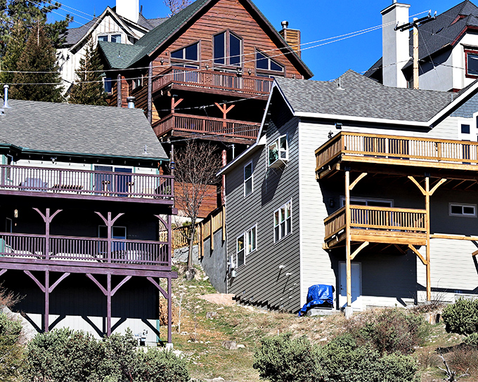 Mountain cabins stack the hillside like architectural Jenga, their wooden decks perfect for morning coffee with a side of pine-scented air.