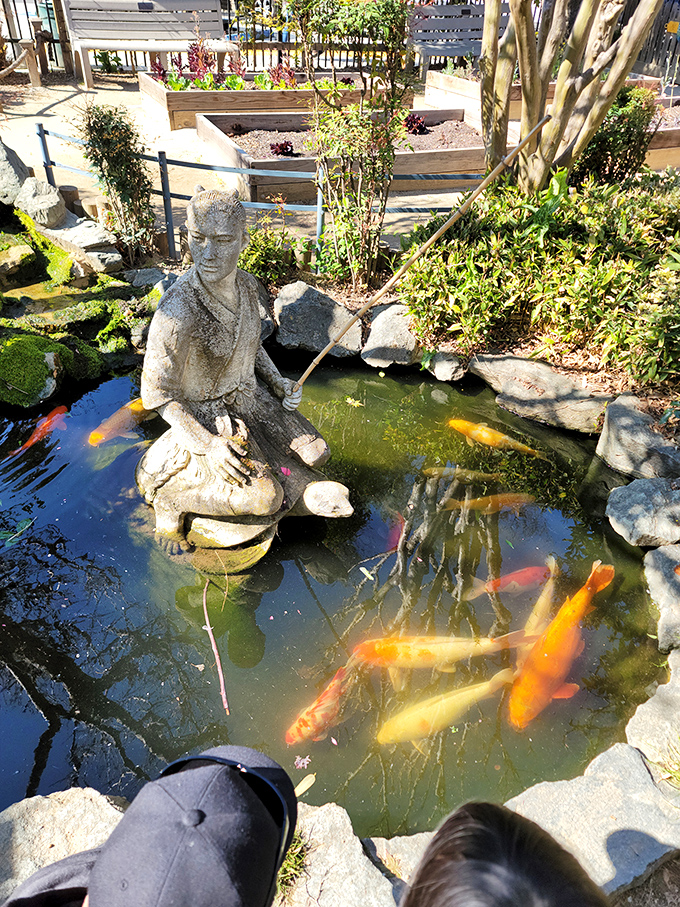 A serene koi pond complete with fishing statue creates a moment of tranquility amid the excitement—proof that even fairytales need occasional quiet chapters.