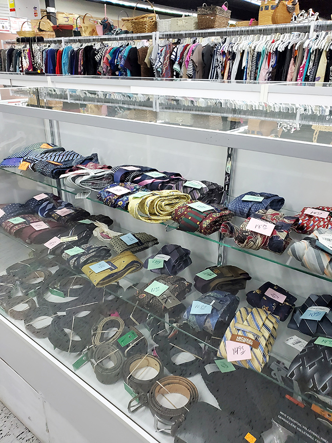 Neckties and belts displayed like colorful snakes behind glass—domesticated fashion reptiles from boardrooms past.