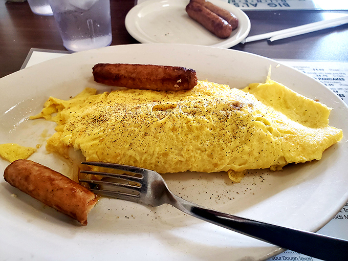 An omelet that's achieved perfect fluffiness, flanked by sausage sentries standing guard. Not that anyone's trying to steal your breakfast.
