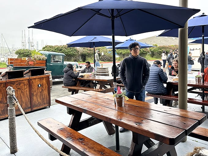 Blue umbrellas dot the outdoor seating area like sails on a harbor, sheltering happy diners from sun and fog alike.