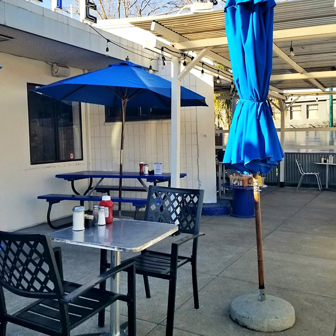 Al fresco dining under blue umbrellas – California sunshine with your coffee. Even the outdoor tables wear their classic diner credentials proudly.