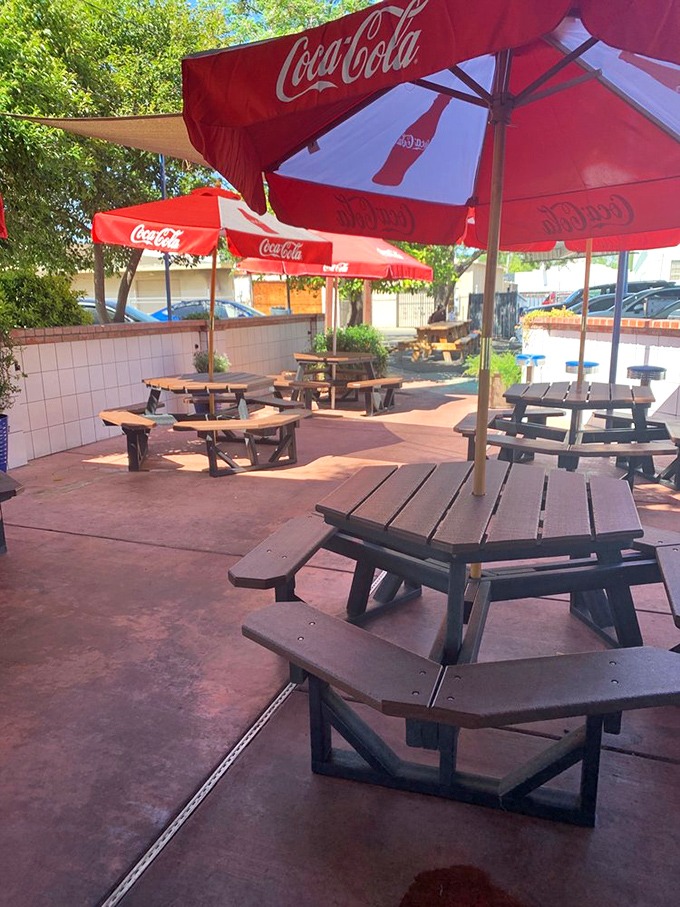 Coca-Cola umbrellas create islands of shade in a sea of picnic tables, where memories are made one bite at a time.