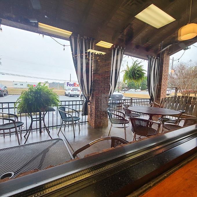 Outdoor seating where striped curtains flutter in the Georgia breeze, turning everyday meals into mini vacations without the TSA pat-down.