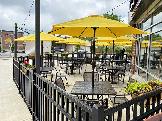 Yellow umbrellas transform an ordinary patio into a sun-drenched oasis where lunch breaks stretch deliciously into the afternoon.