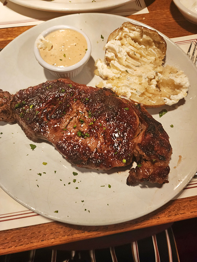 The ribeye steak arrives with a crust that should be illegal, accompanied by a loaded baked potato that's a meal unto itself.