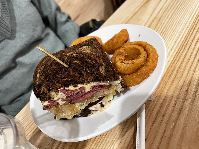 The Reuben sandwich, reimagined but respectful of tradition. Those onion rings aren't just a side&mdash;they're a golden-fried bonus track.