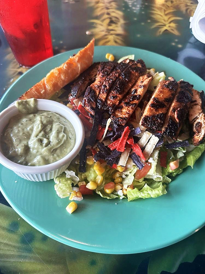 A salad that doesn't apologize for being healthy. Grilled protein and fresh vegetables having a party on a turquoise plate.