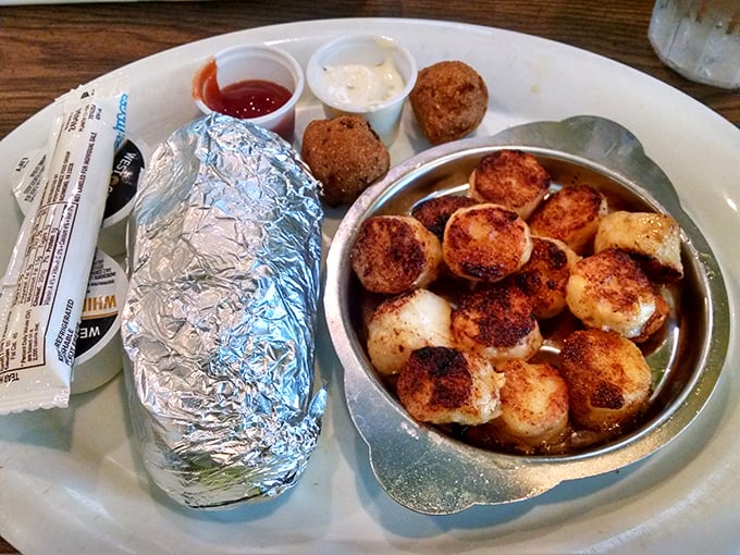 Seared scallops that taste like the ocean's finest gift, served alongside a baked potato wrapped like a precious silver package.