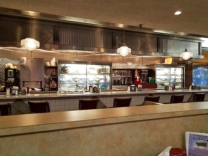 The counter—where solo diners find community, servers perform their choreographed dance, and the kitchen reveals glimpses of culinary magic in progress.