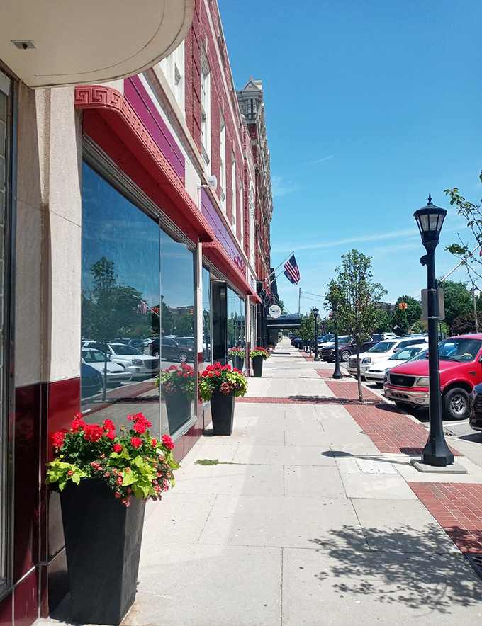 Flower-lined sidewalks invite leisurely strolls past storefronts where window shopping is still a legitimate afternoon activity.
