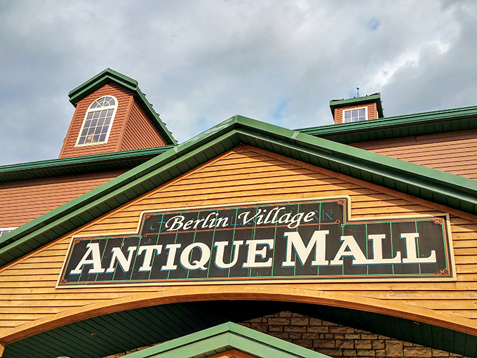 The Berlin Village Antique Mall sign promises adventure beneath its weathered facade&mdash;a portal to the past for the present-day explorer.