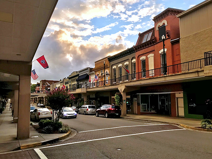 Sunset casts a golden glow on Morristown's Main Street, where Tennessee flags flutter above the Skymart in a scene that defines small-town Americana.