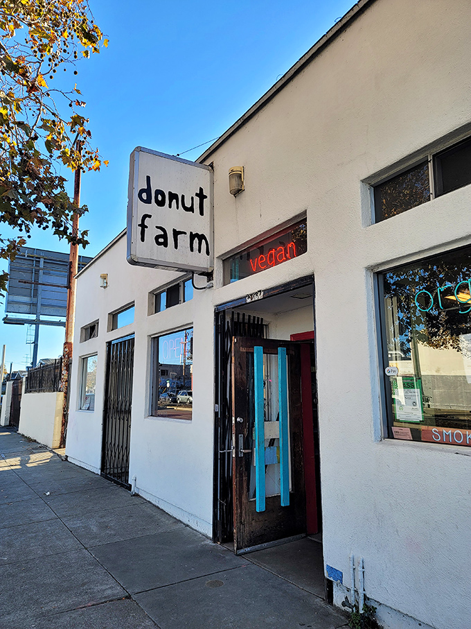 Donut Farm's minimalist sign and bright pink donut mural &ndash; where vegan treats prove plant-based can be indulgent too.