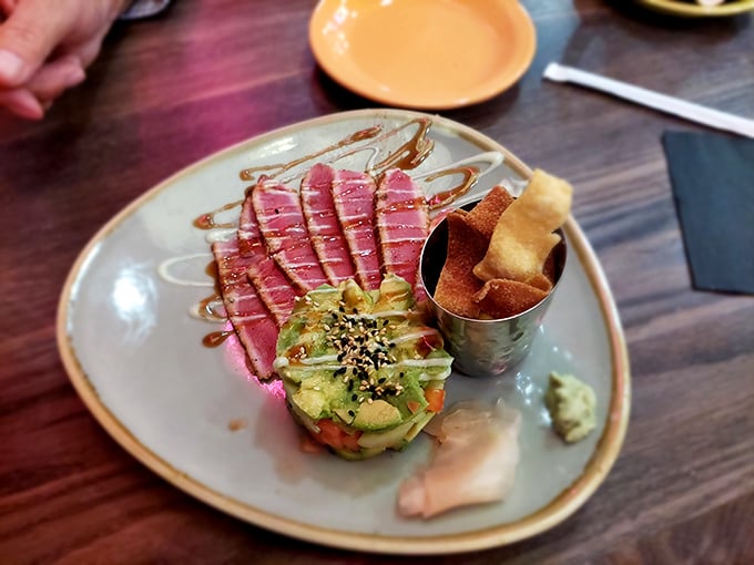 This isn't just tuna&mdash;it's an architectural achievement. Rare ahi balanced atop avocado with crispy wonton strips standing guard like delicious sentinels.