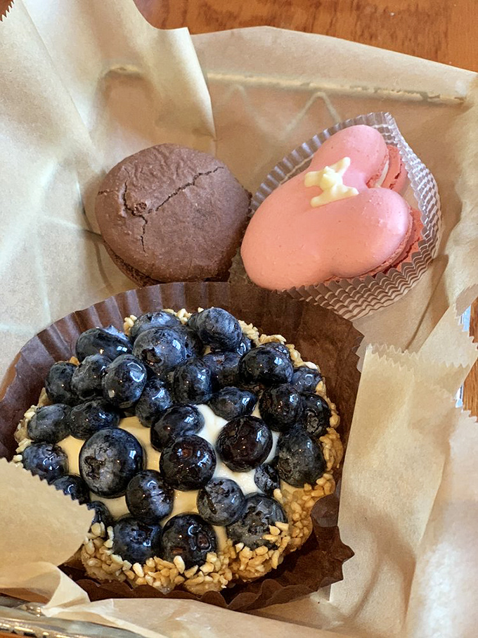 A blueberry tart surrounded by chocolate and pink companions. It's the dessert version of a buddy comedy, where everyone gets along deliciously.
