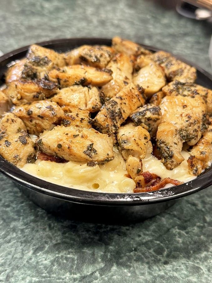Herb-seasoned chicken perched atop a golden pool of cheese sauce&mdash;visual evidence that someone in that kitchen truly cares.