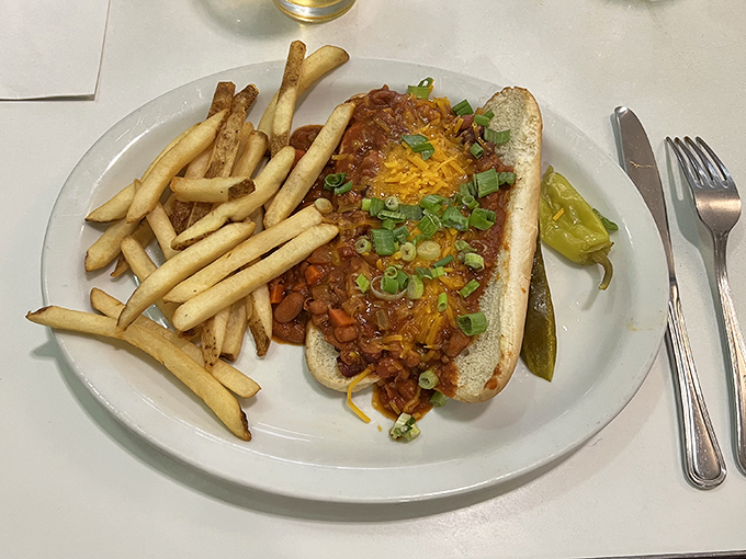 The chili dog arrives like it's auditioning for a food commercial &ndash; cheese melting into spicy chili, green onions adding color, and fries standing at attention.