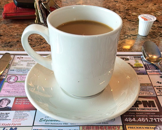 Coffee served on a placemat of local ads &ndash; the quintessential diner experience where your caffeine comes with community connections.