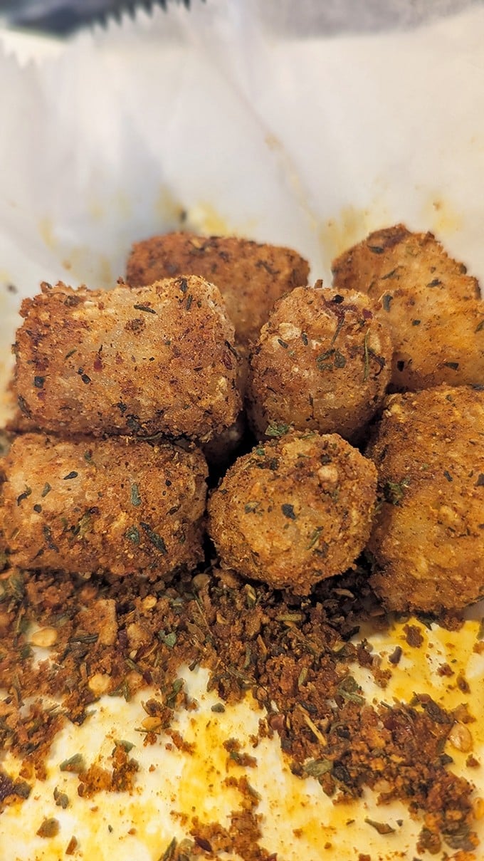 Mac and cheese bites with herbs and seasoning&mdash;little golden spheres of comfort that make perfect chicken wing companions.