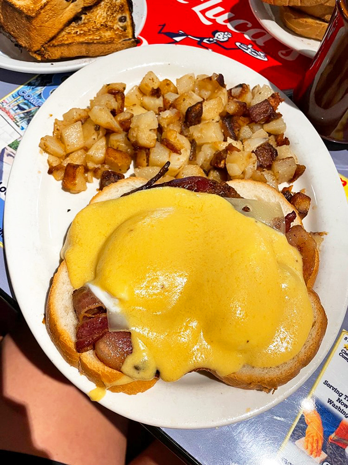 Eggs Benedict: where hollandaise sauce falls like golden sunshine on an English muffin kingdom. Home fries complete the royal court.