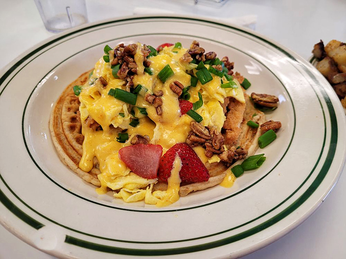 A waffle that's become the canvas for a breakfast masterpiece&mdash;scrambled eggs, fresh fruit, and pecans create sweet-savory harmony on a plate.