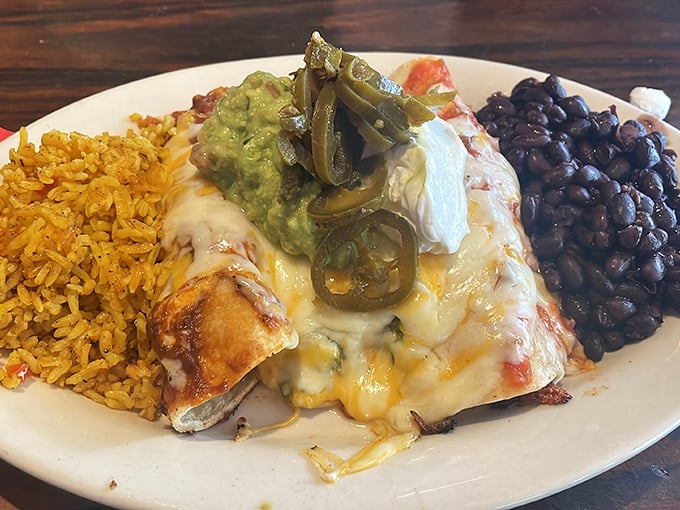 This enchilada doesn't just sit on the plate&mdash;it lounges luxuriously under a blanket of melted cheese, with rice and beans as faithful companions.