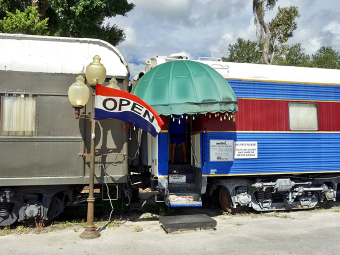 The entrance beckons with old-world charm&mdash;vintage lamppost, welcoming awning, and colorful train cars promising an experience that's definitely off the rails.
