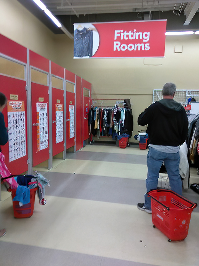 The fitting room corridor&mdash;where retail dreams face their final test. That gentleman's shopping basket promises a successful expedition.