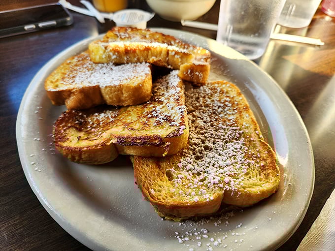French toast that wears its powdered sugar like a light dusting of snow. Simple pleasures elevated to art form status on an unassuming plate.