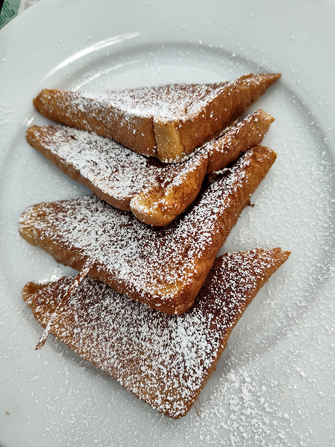 French toast dusted with powdered sugar—architectural in its presentation, humble in its ingredients, and absolutely magnificent in execution.