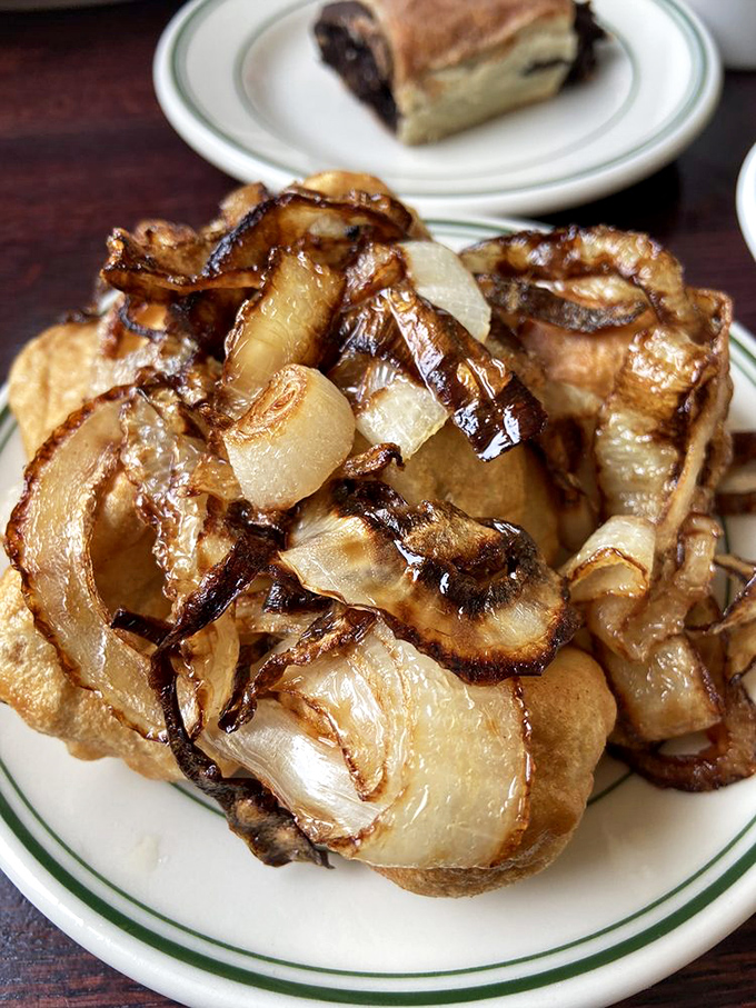 Fried kreplach with caramelized onions&mdash;crispy, savory pillows of dough that prove sometimes the best things in life are both simple and indulgent.