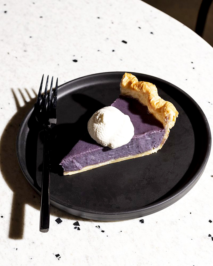 This slice of purple pie isn't just dessert, it's a conversation piece&mdash;its vibrant hue and perfect dollop of cream suggesting the kitchen isn't afraid of bold choices.