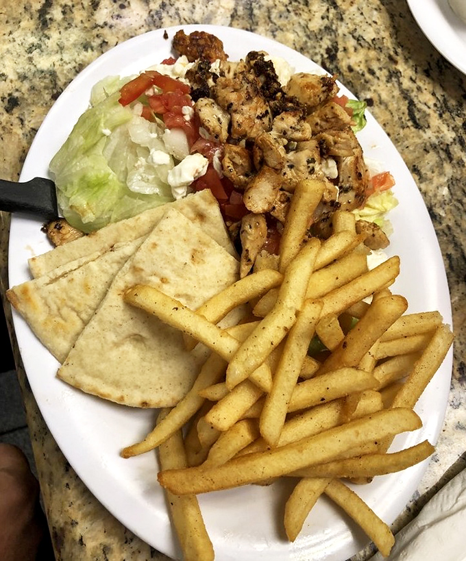 A lunch plate that covers all the bases: protein, greens, carbs, and just enough guilt to make it satisfying. That pita bread is ready for its supporting role. 