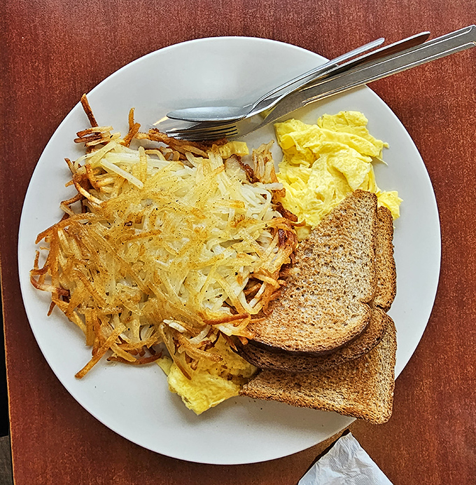 The holy trinity of breakfast perfection: golden hash browns with the ideal crisp-to-tender ratio, fluffy eggs, and toast standing by for cleanup duty.
